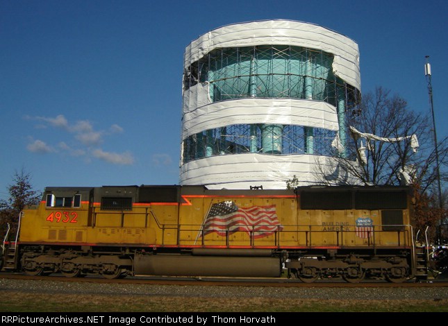 UP 4932 leads NS 11J passed a partially plastic wrapped tower